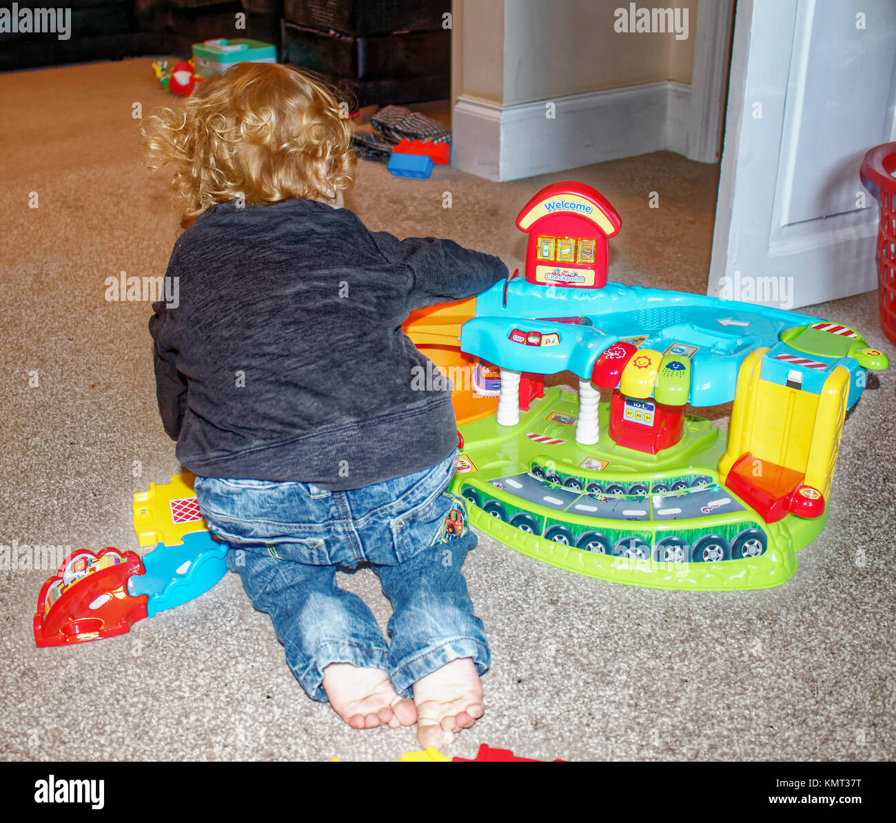 Little boy playing with toy cars and toy garage Stock Photo - Alamy