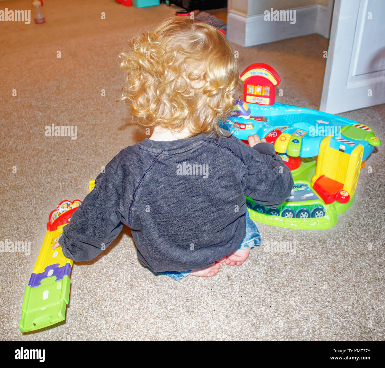 Toddler playing with toy garage Stock Photo - Alamy