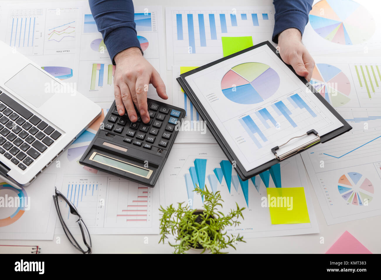 Businessman holding a pen is working with graph documents and sunset ...