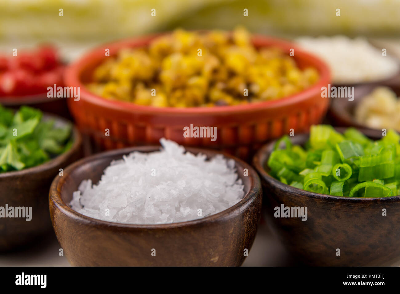 Flakes of Sea Salt in Wooden Bowl in front of roasted corn Stock Photo ...