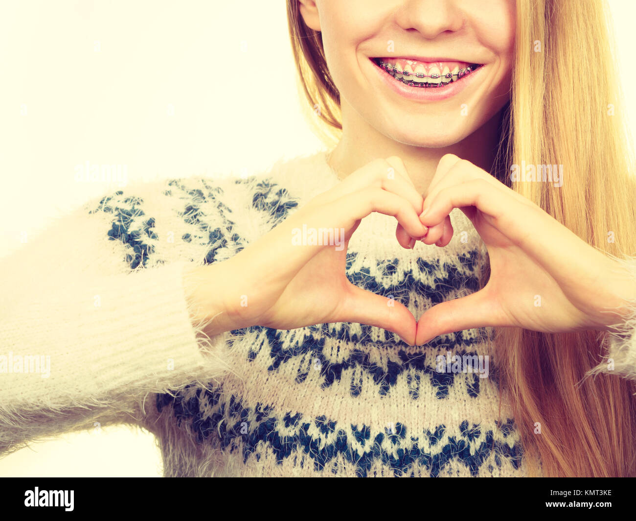 Gestures, signs and symbols concept. Teenage girl making heart sign ...