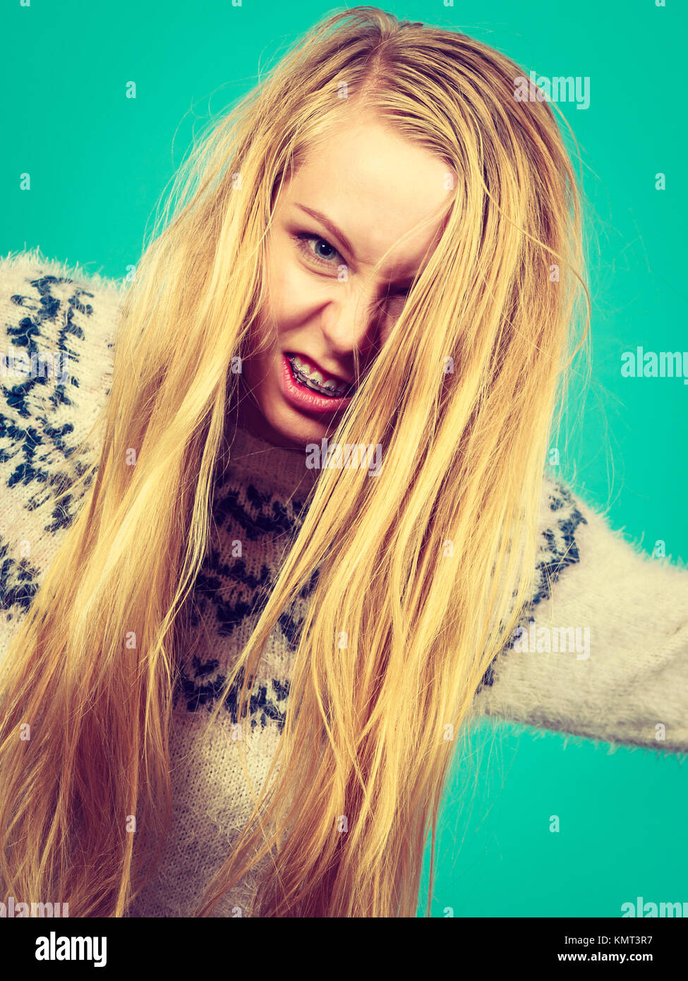 Fooling around concept. Young blonde teenage woman making scary faces ...