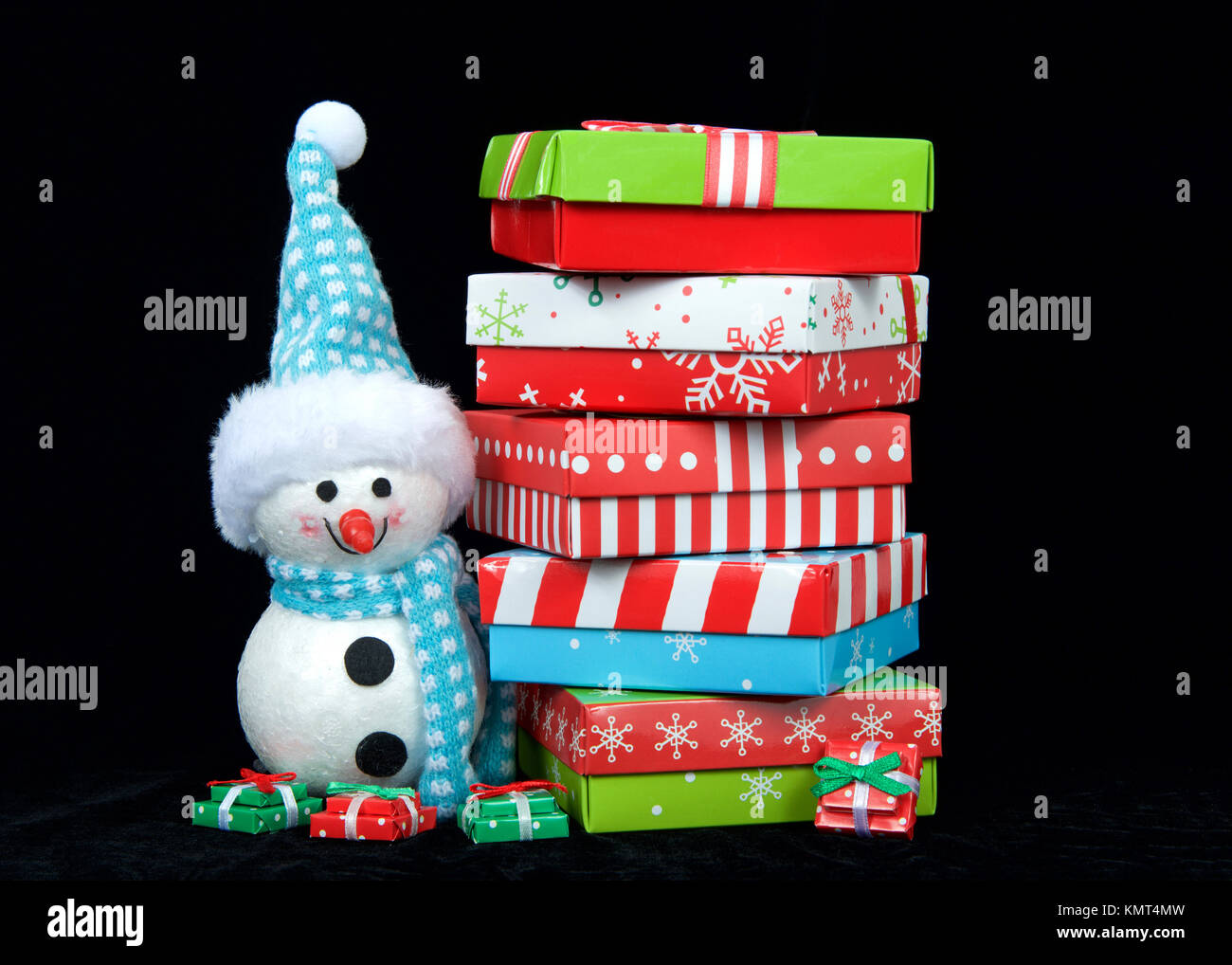 Small snowman standing next to a pile of colorful boxes Christmas ...