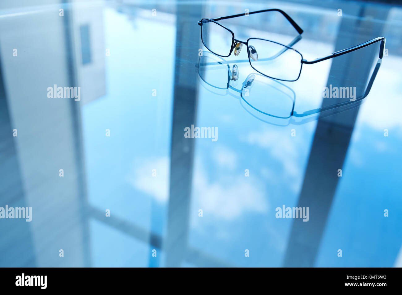 Image of eyeglasses on workplace and its reflection Stock Photo - Alamy