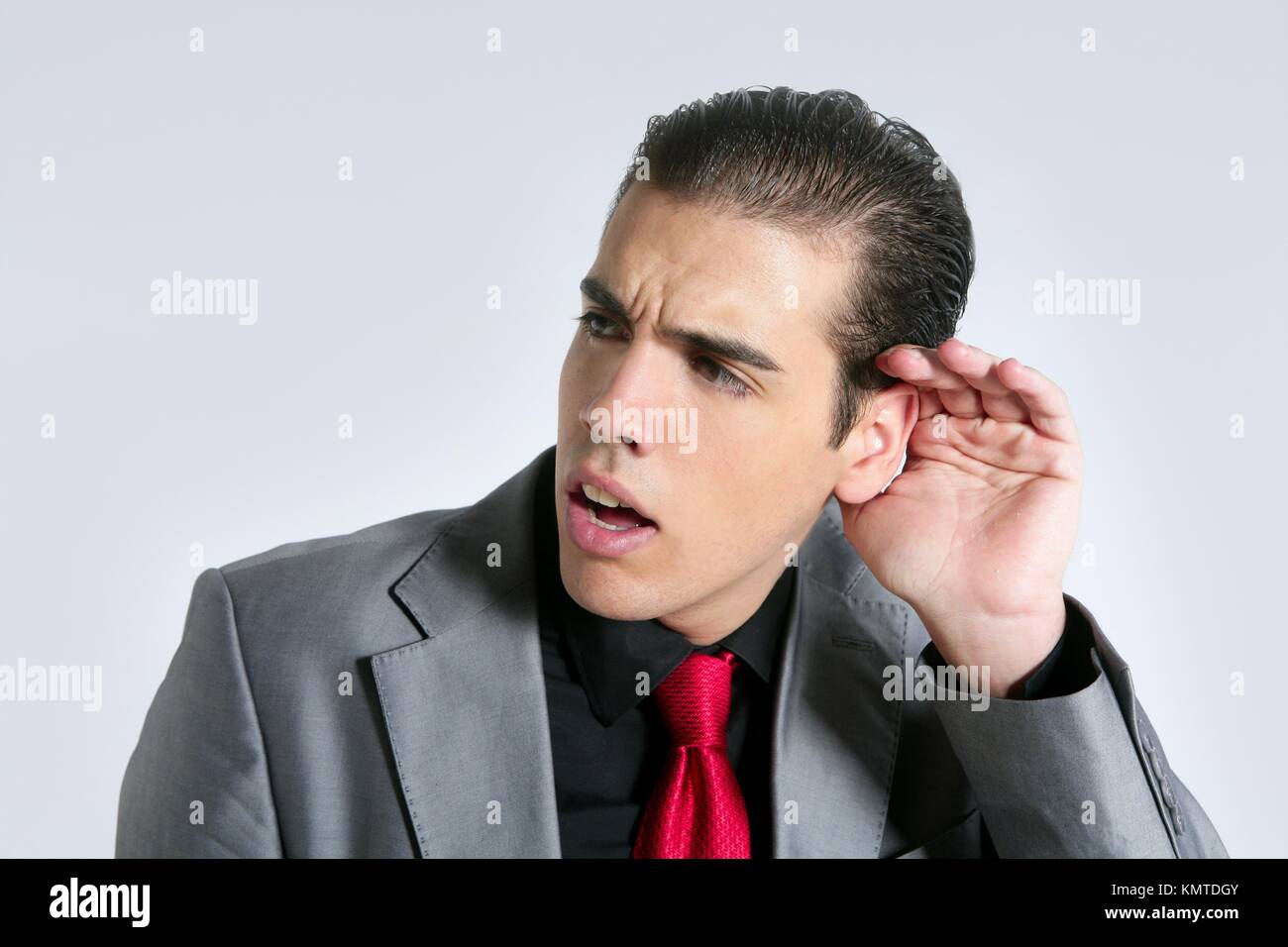 Businessman with hand in ear as a deafness sign gesture Stock Photo - Alamy