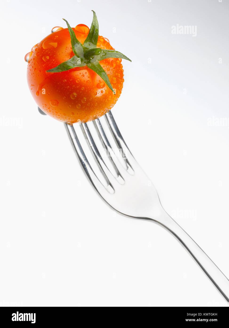 tomato fork piercing Stock Photo - Alamy