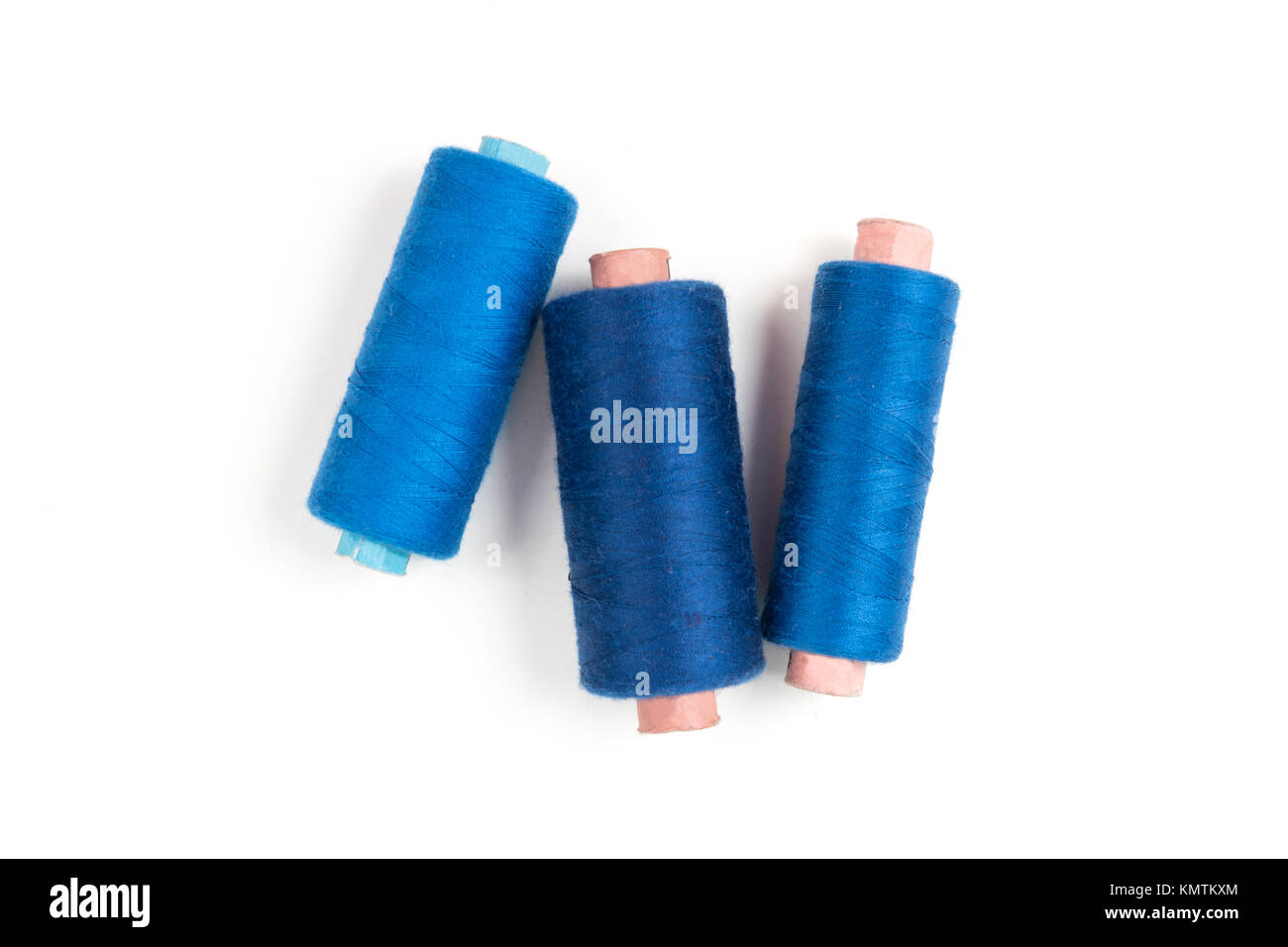 Three Blue sewing threads on a white background Stock Photo - Alamy