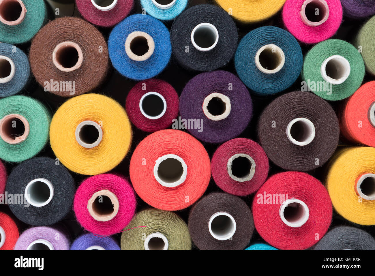 Stacked colored sewing threads, textile background and colorful ...