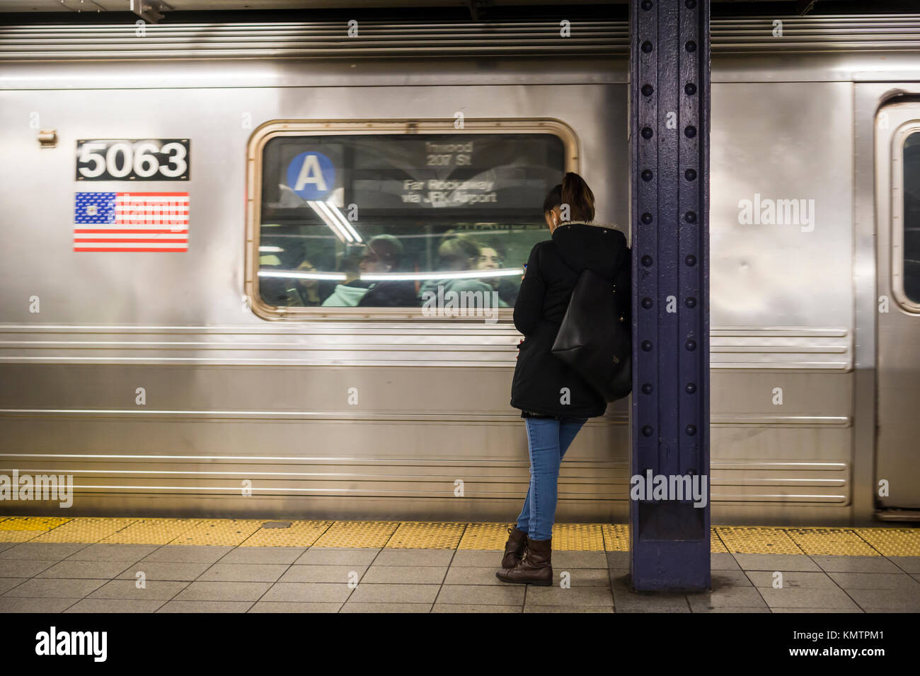 A distracted rider as a train arrives at the Chambers Street subway ...