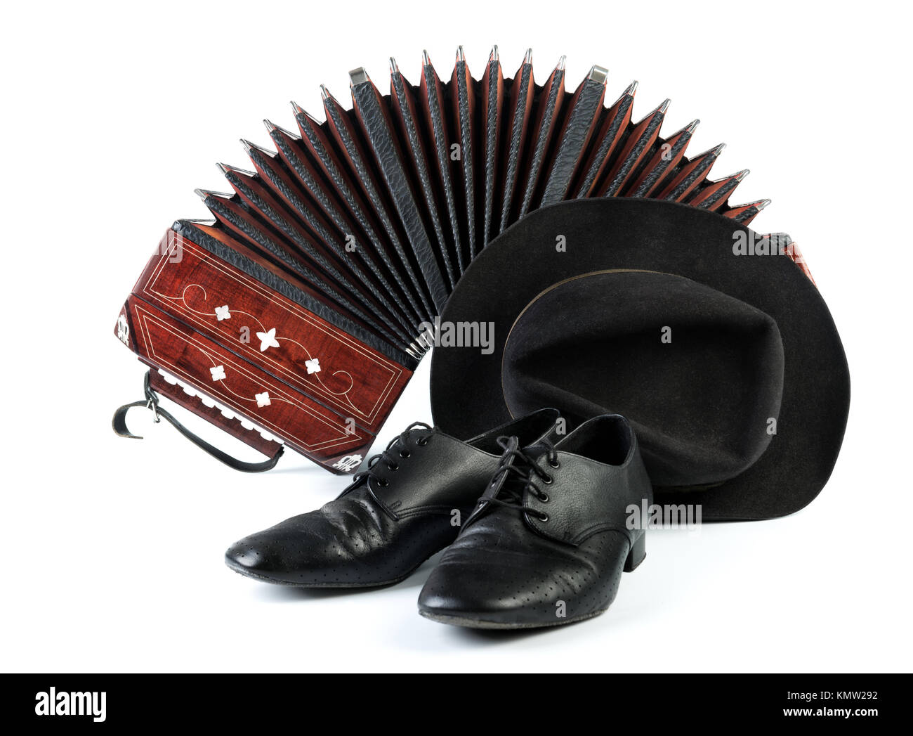 Bandoneon, pair of tango shoes and a black hat on white background ...