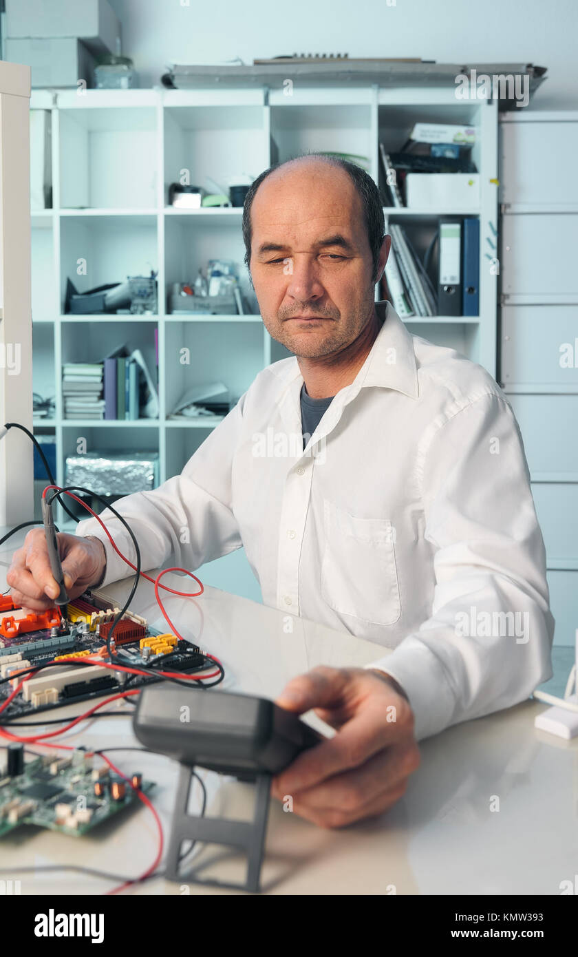 Senior male tech tests electronic equipment, toned image Stock Photo ...