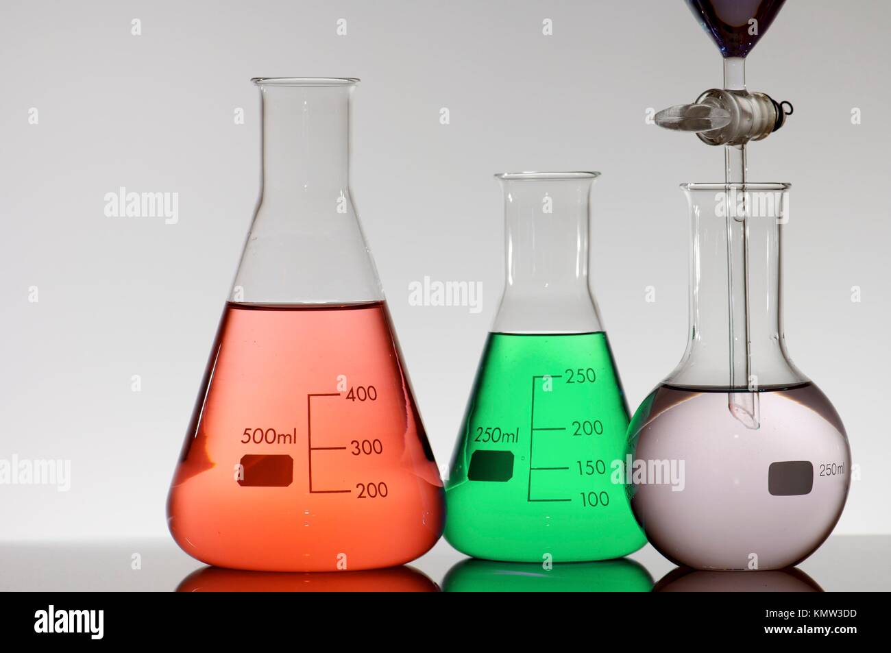 three flasks with colored liquid on a white background Stock Photo - Alamy