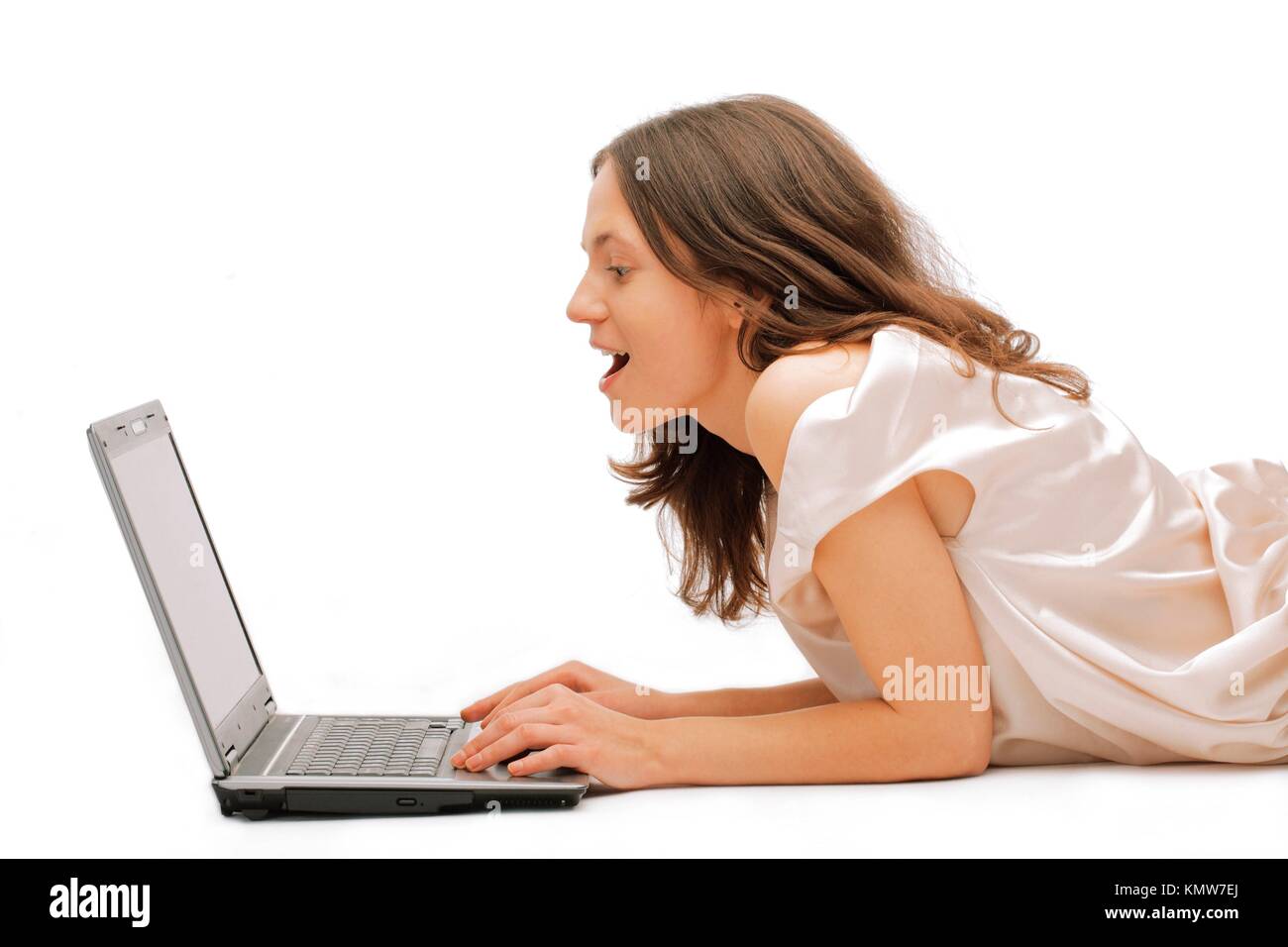 Profile view of a happy young female using a laptop over white ...