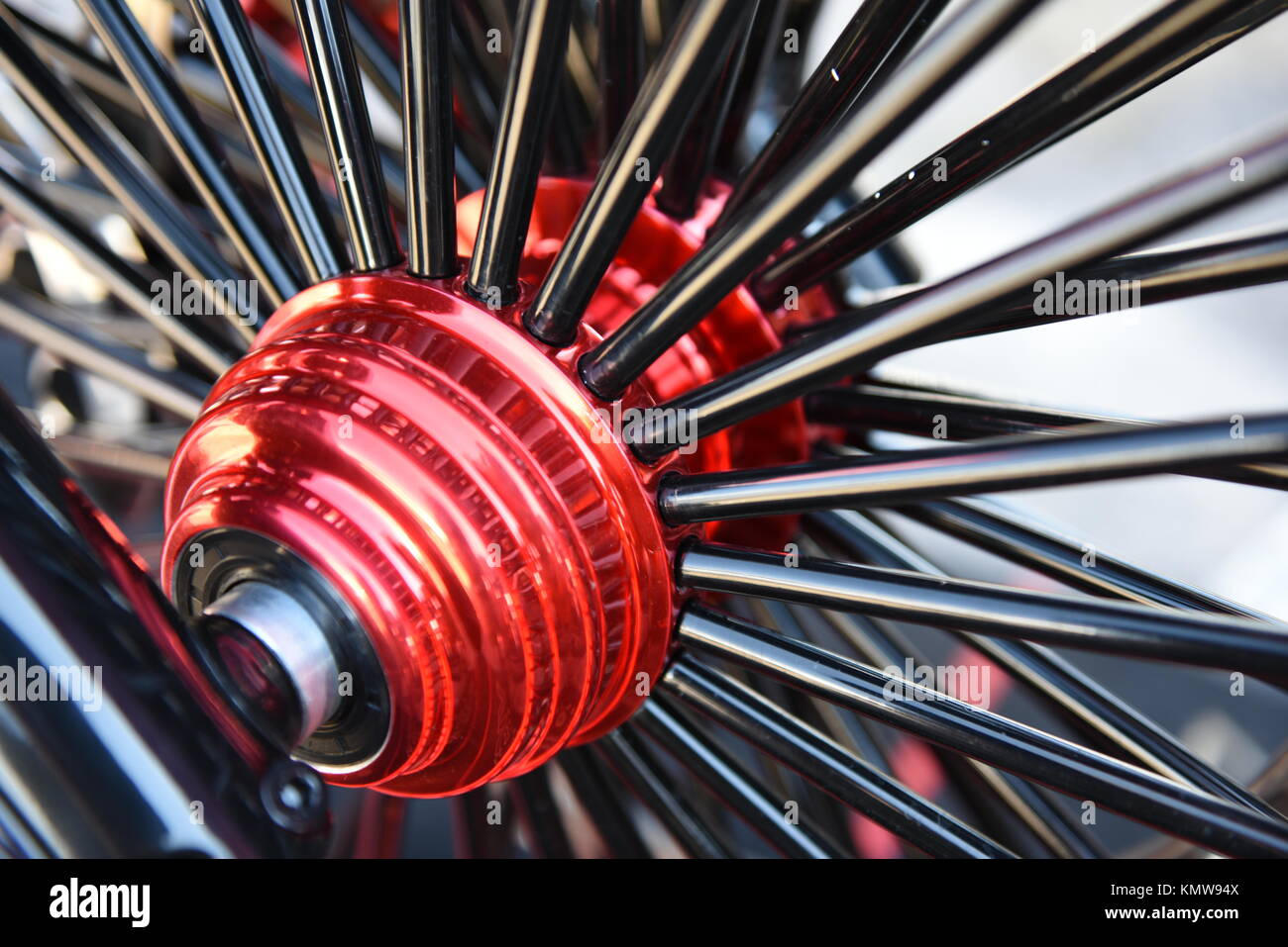 Chopper motorcycle wheel closeup with a pattern of shiny black spokes ...