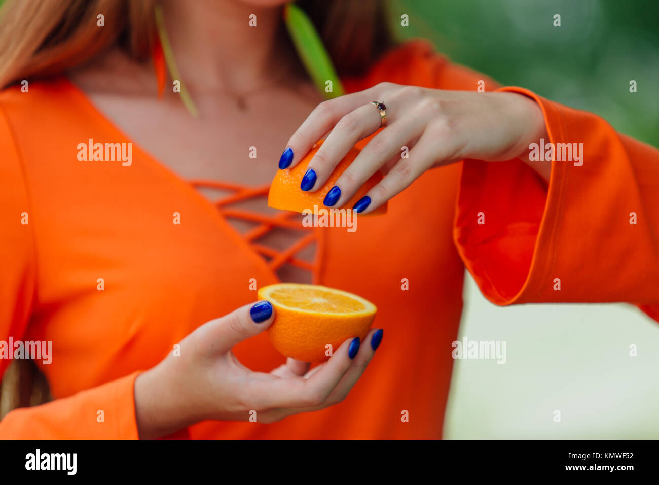 Halves of orange in hands Stock Photo - Alamy