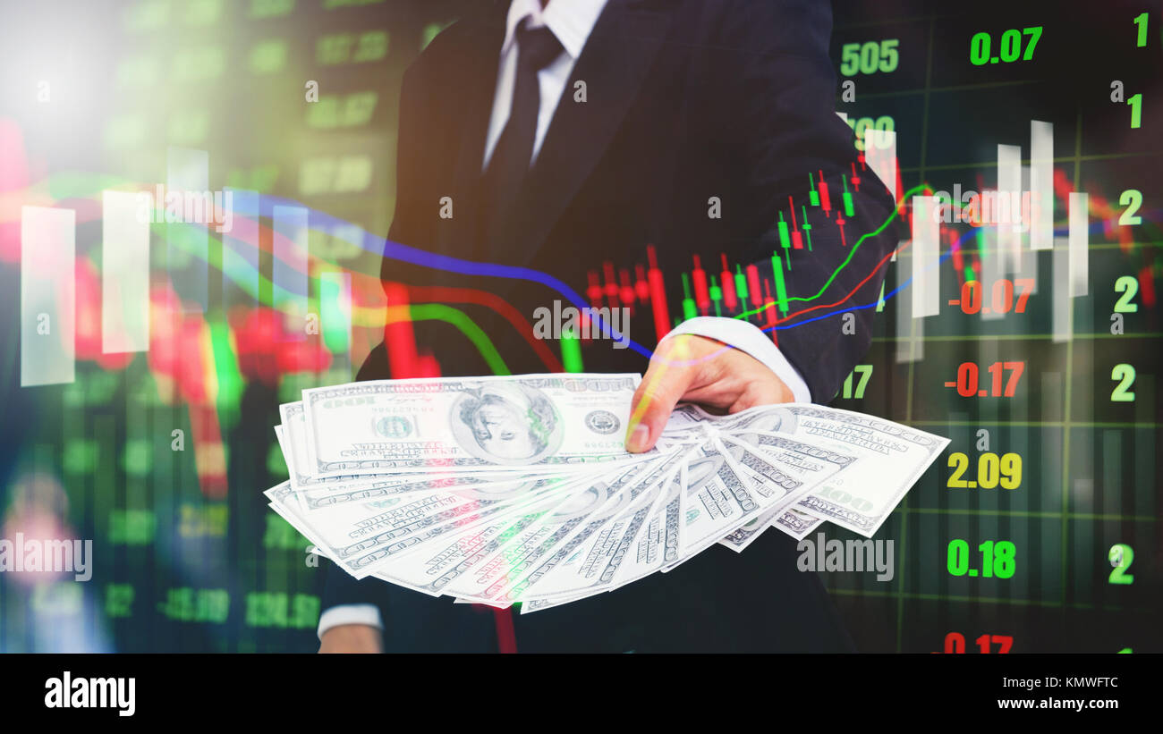 Businessman Holding money US dollar bills on digital stock market ...
