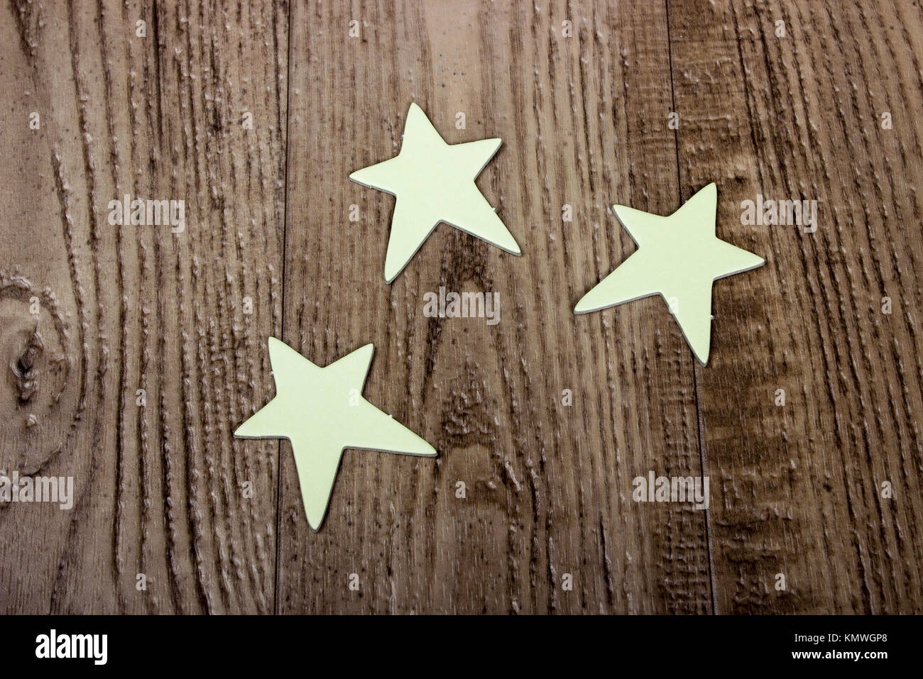 yellow, green cardboard stars laying on a dark wood grained floor Stock ...