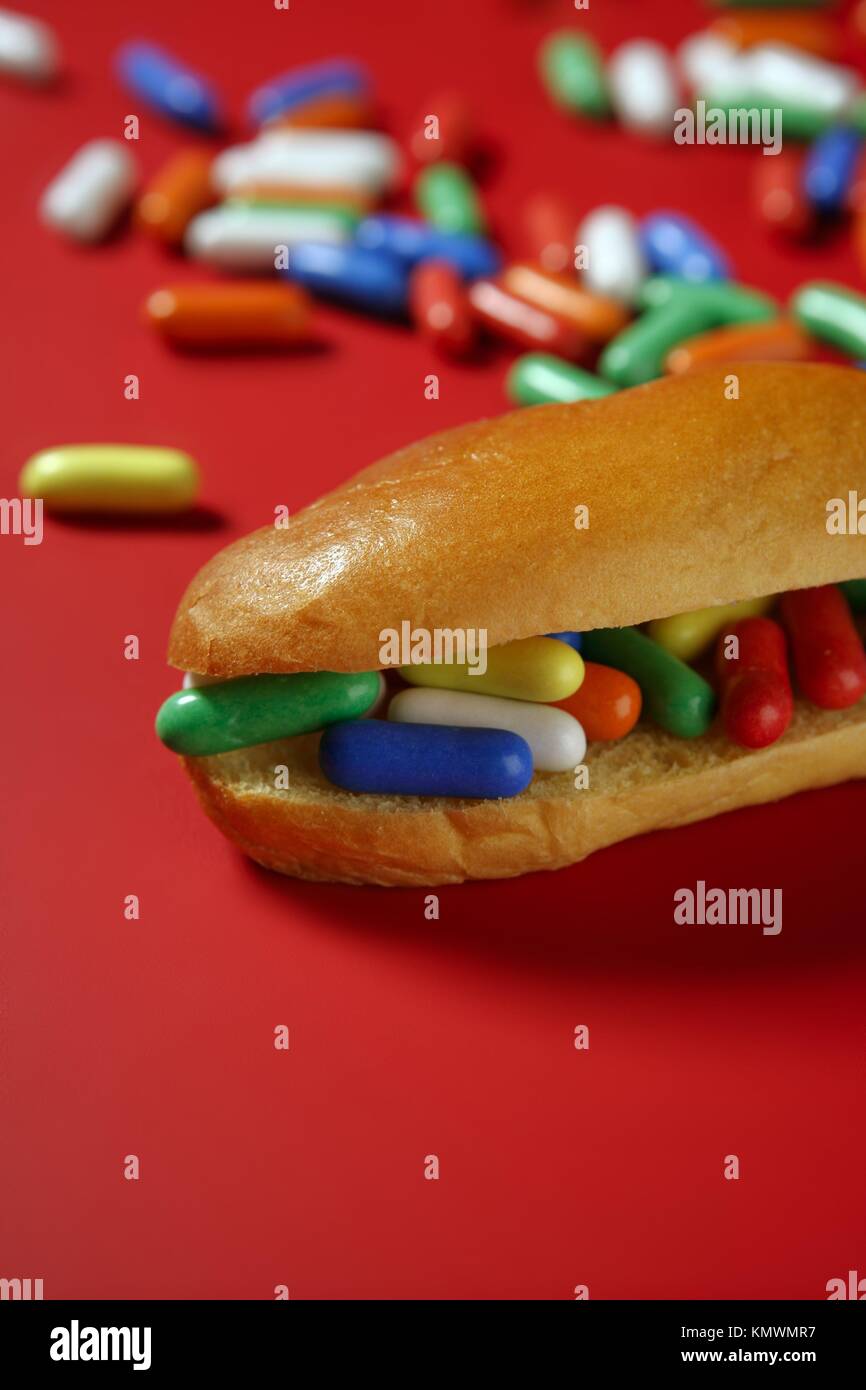 Candy sandwich sweet metaphor over red background Stock Photo - Alamy