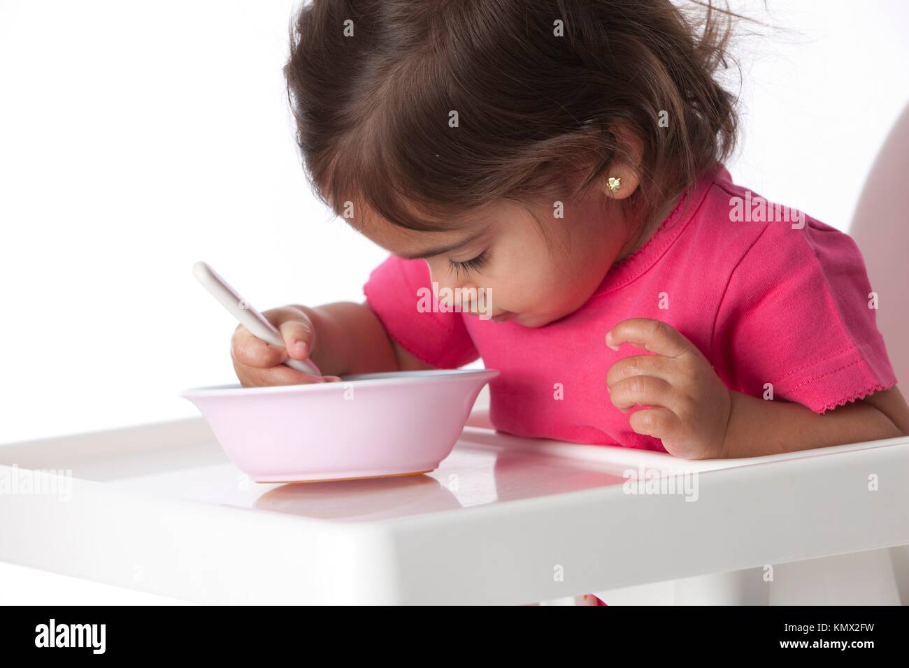 Baby girl eating by herself hi-res stock photography and images - Alamy