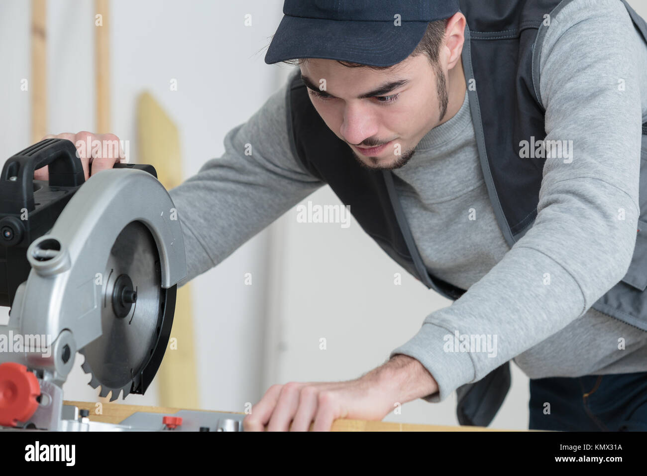 young carpenter using circular saw for wood inside warehouse Stock ...