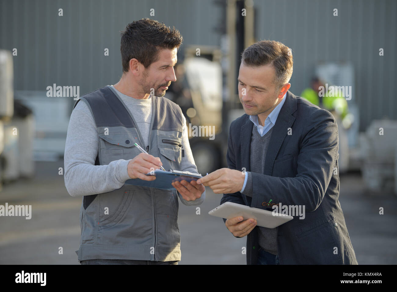two workers outside a factory Stock Photo - Alamy