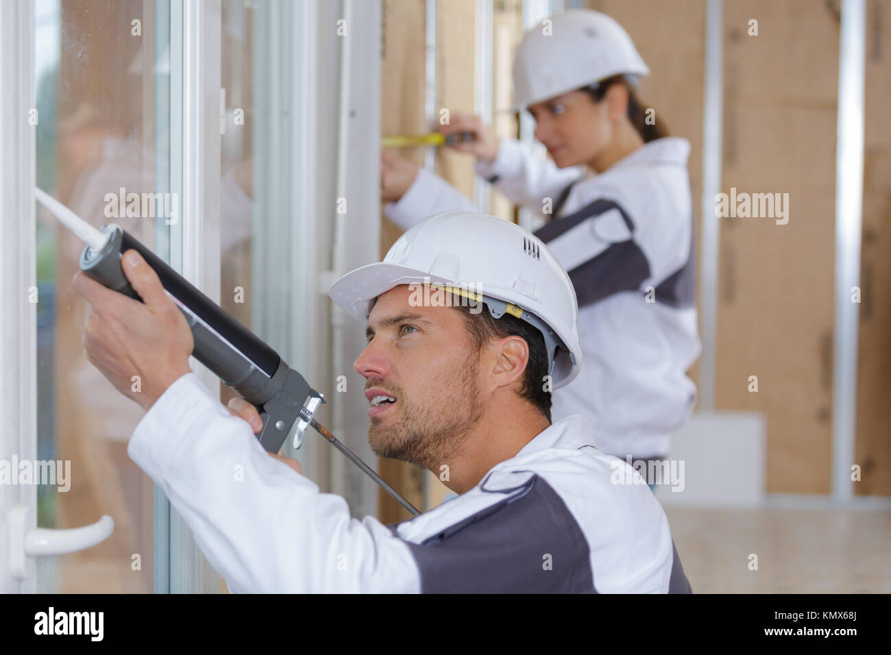 team of construction workers installing window in house Stock Photo - Alamy