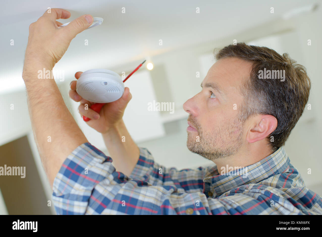 Electrician fitting a fire alarm Stock Photo - Alamy