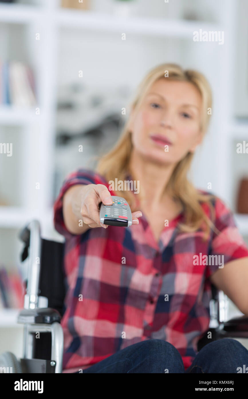 Lady in wheelchair using remote control Stock Photo - Alamy