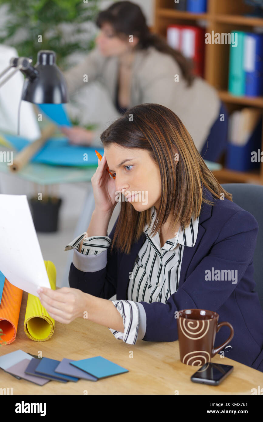 female office worker reading a document Stock Photo - Alamy