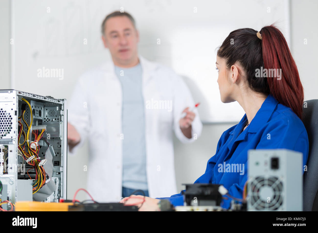 Teacher at whiteboard, student with dismantled computer Stock Photo - Alamy