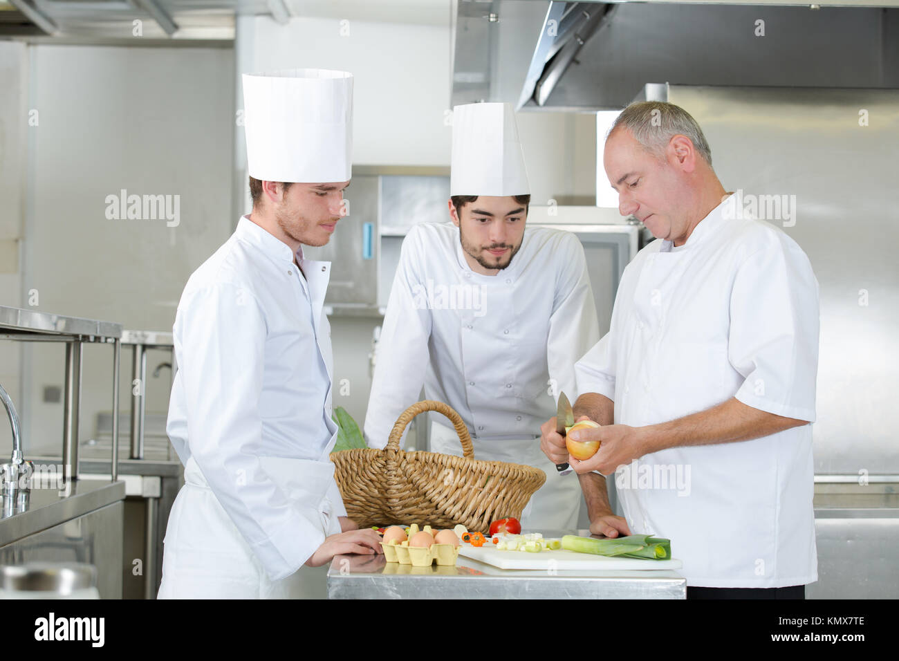 chef and apprentice cooks working at restaurant kitchen together Stock ...