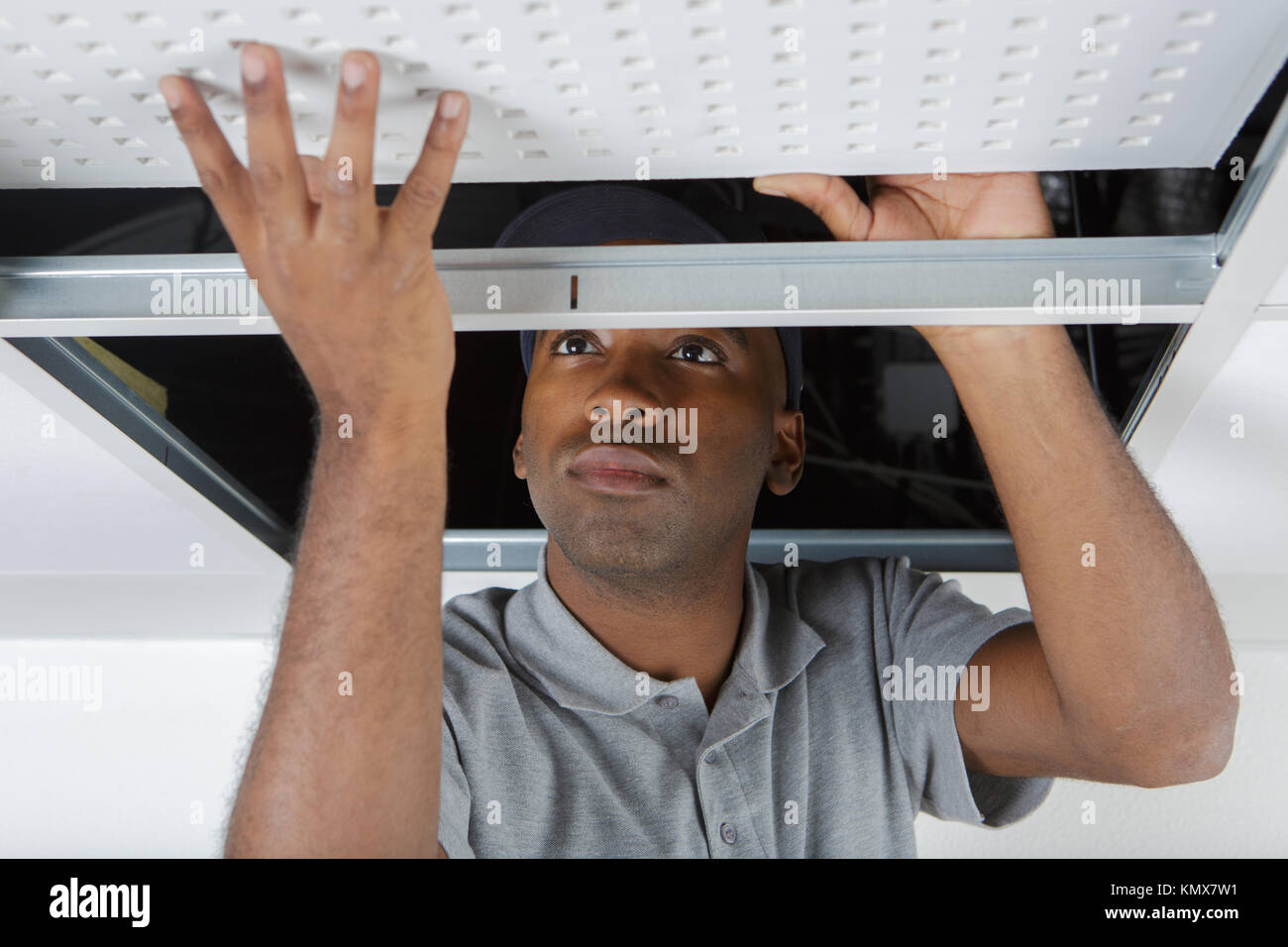 man installs suspended ceiling in house Stock Photo - Alamy