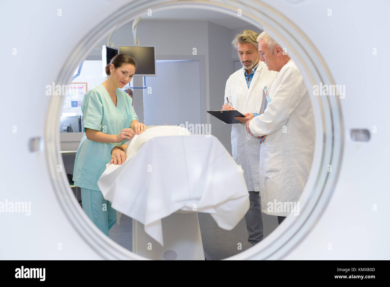 View of medical team through circular mri scanner Stock Photo - Alamy