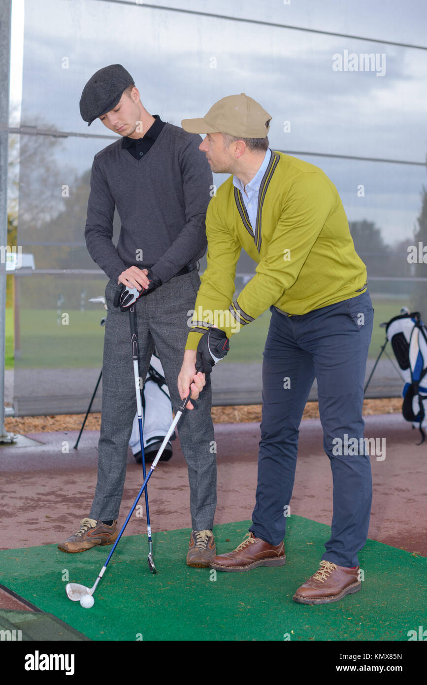 male golf instructor teaching golf player Stock Photo - Alamy