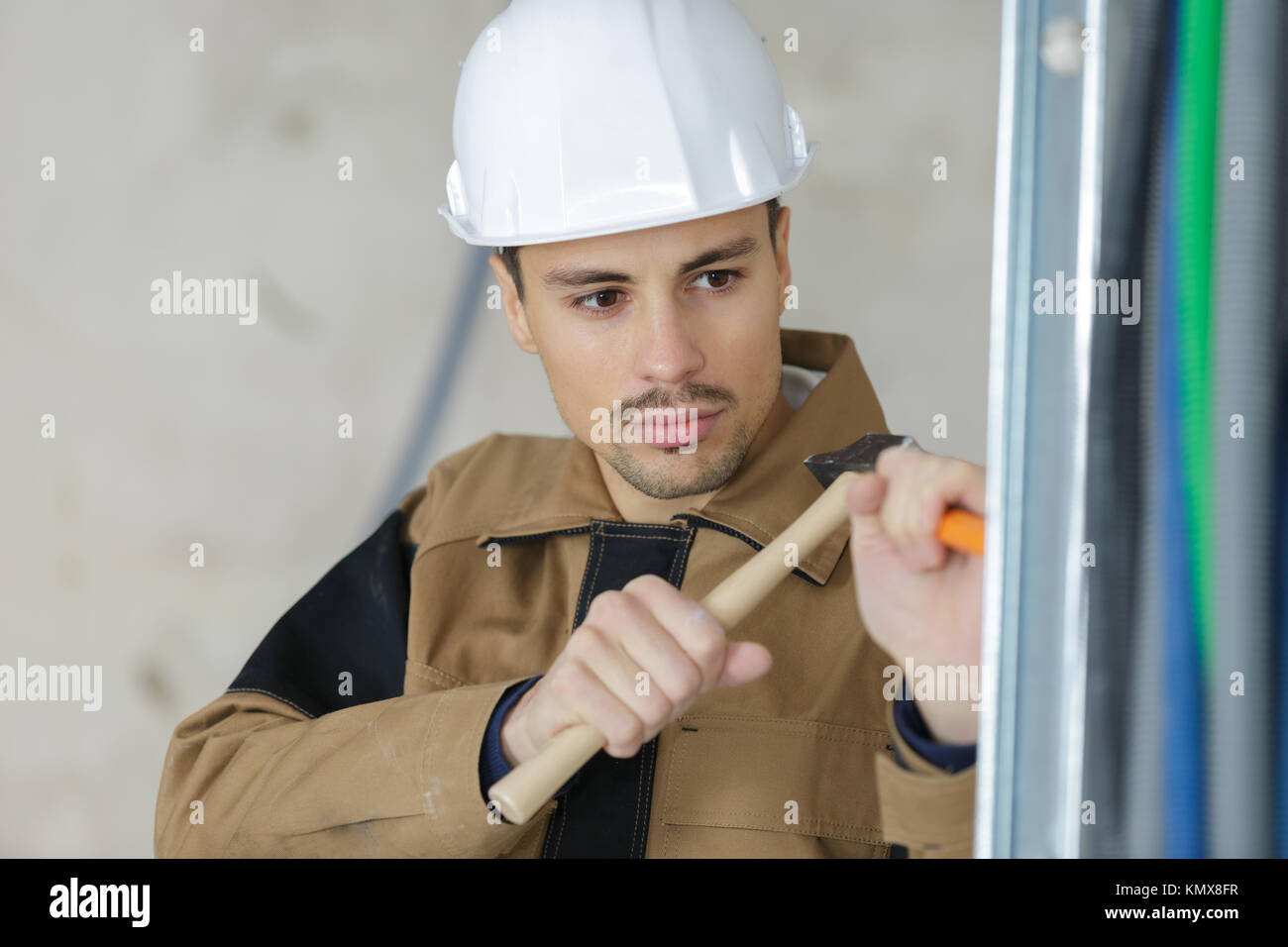young mason with chisel and hammer restores building Stock Photo - Alamy