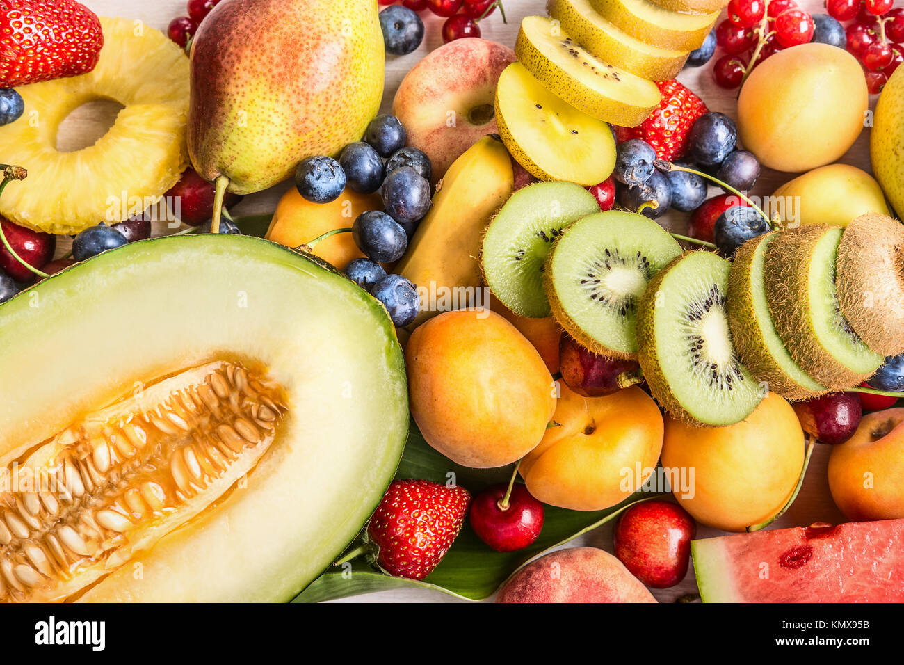 Variety of colorful summer fruits background: melon, sliced kiwi,banana ...