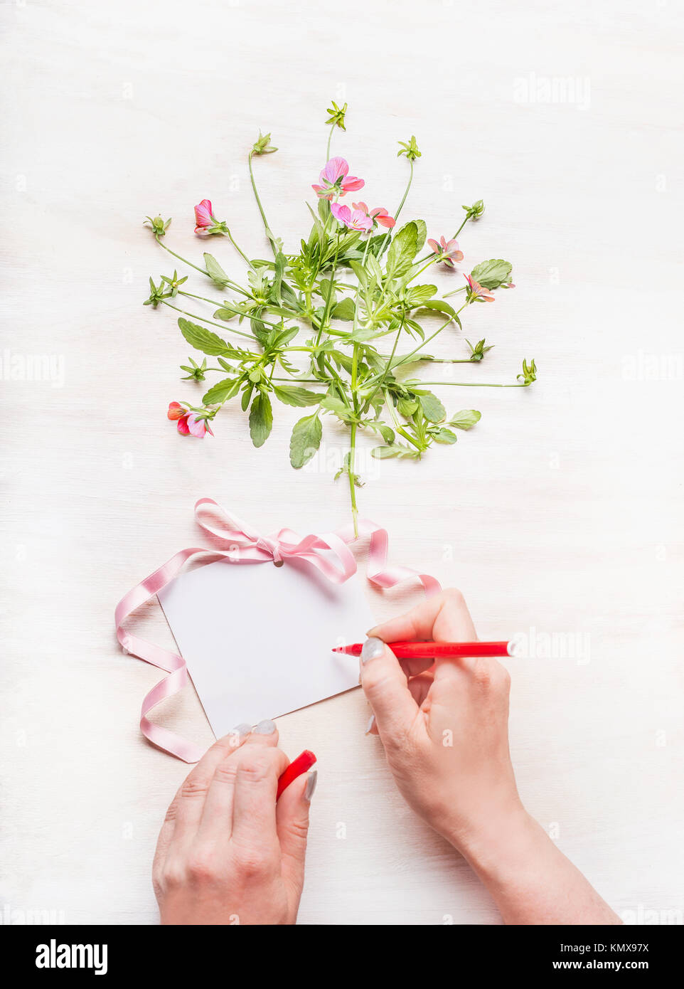 Female hand Write a greeting card on white wooden background with ...