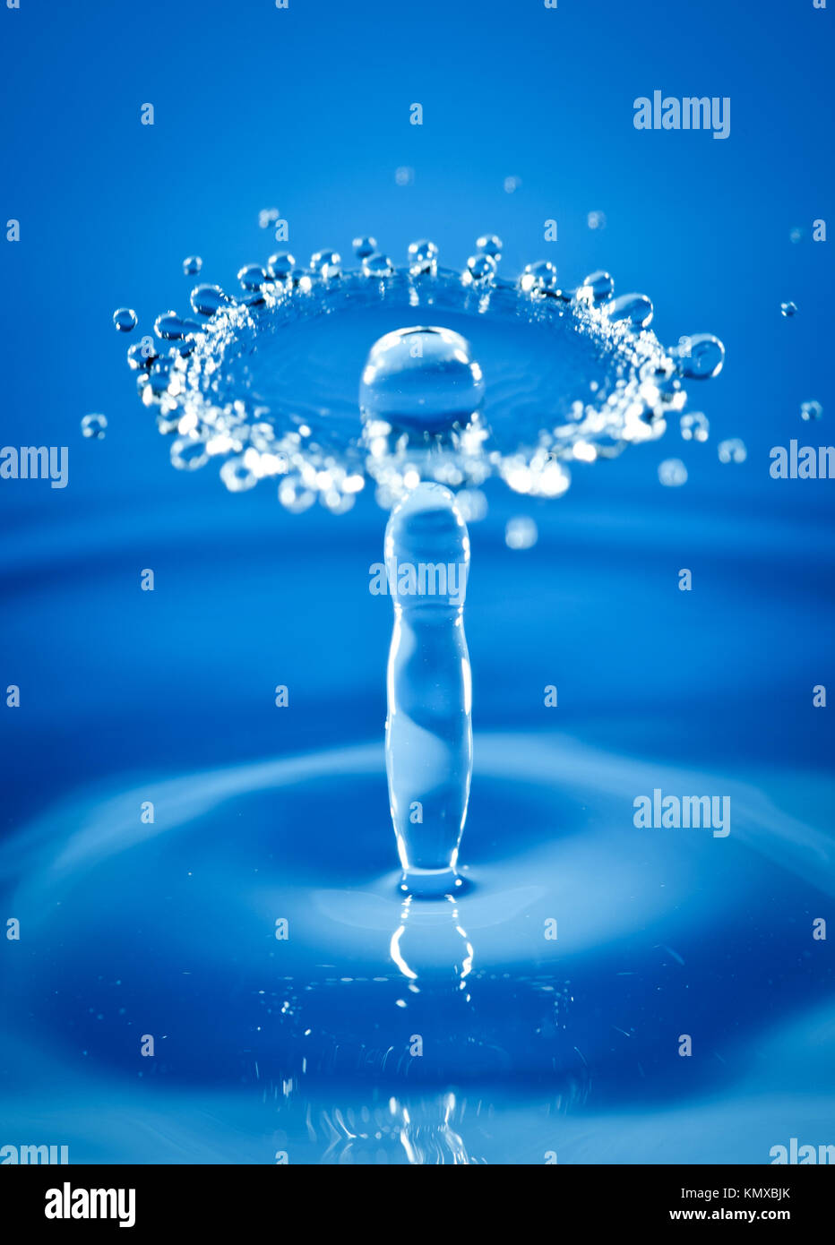 water drop falls downwards breaking about a drop Stock Photo - Alamy