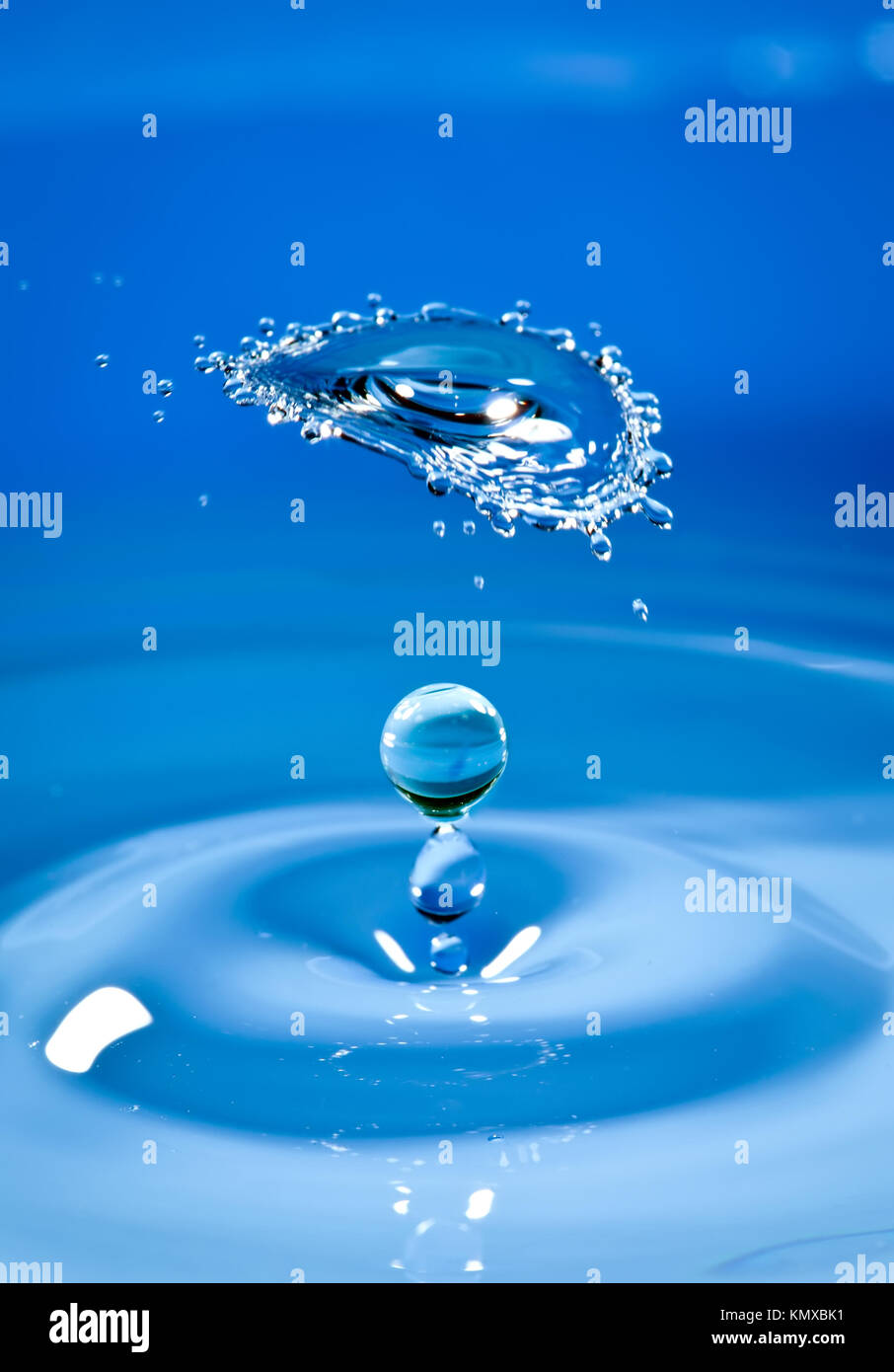water drop falls downwards breaking about a drop Stock Photo - Alamy