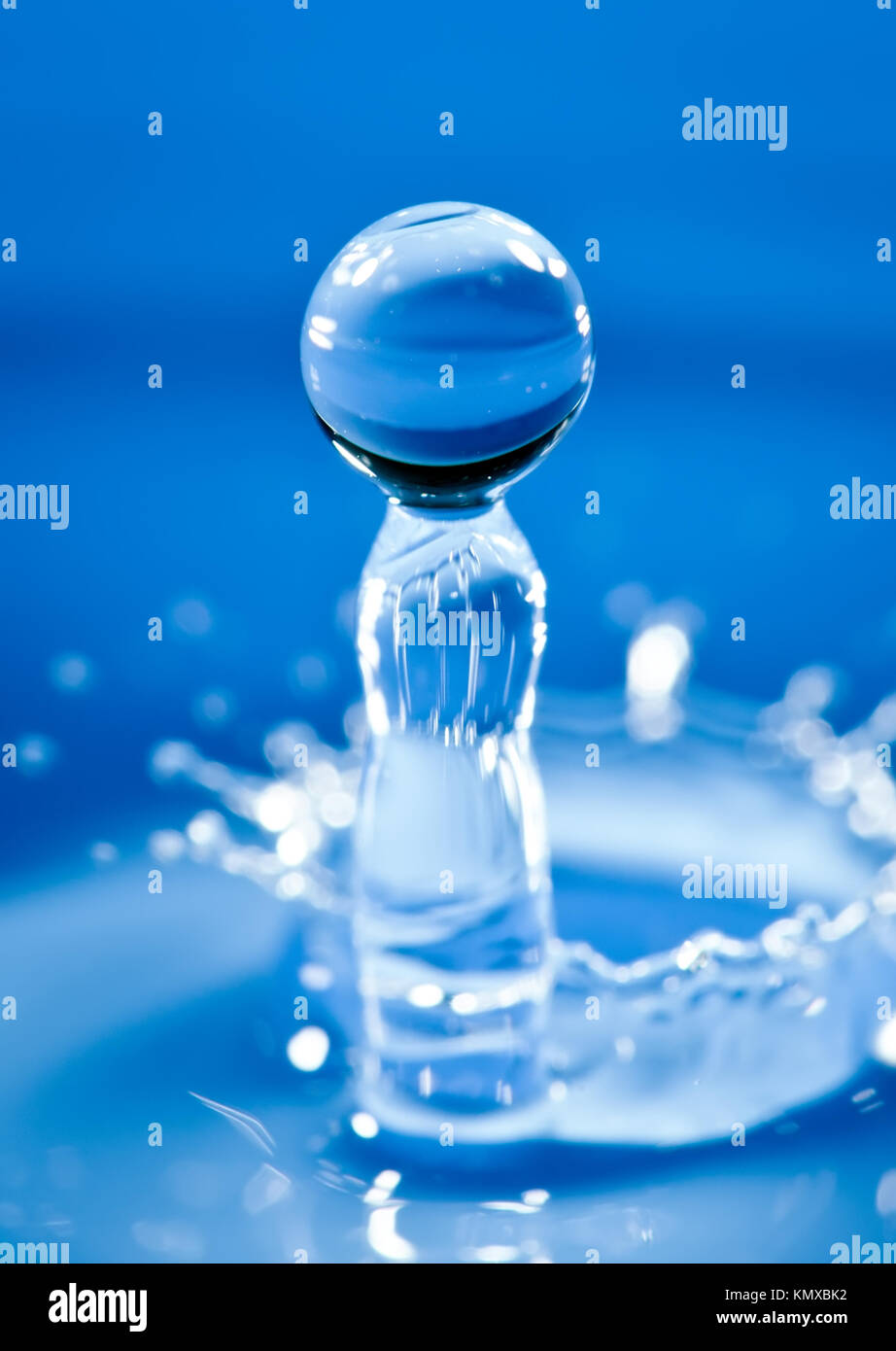 water drop falls downwards breaking about a drop Stock Photo - Alamy