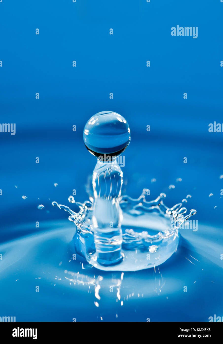 water drop falls downwards breaking about a drop Stock Photo - Alamy