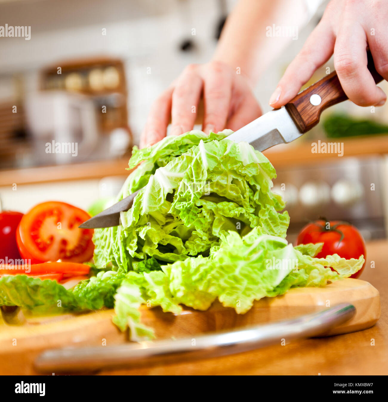 Woman's hands cutting lettuce, behind fresh vegetables Stock Photo - Alamy