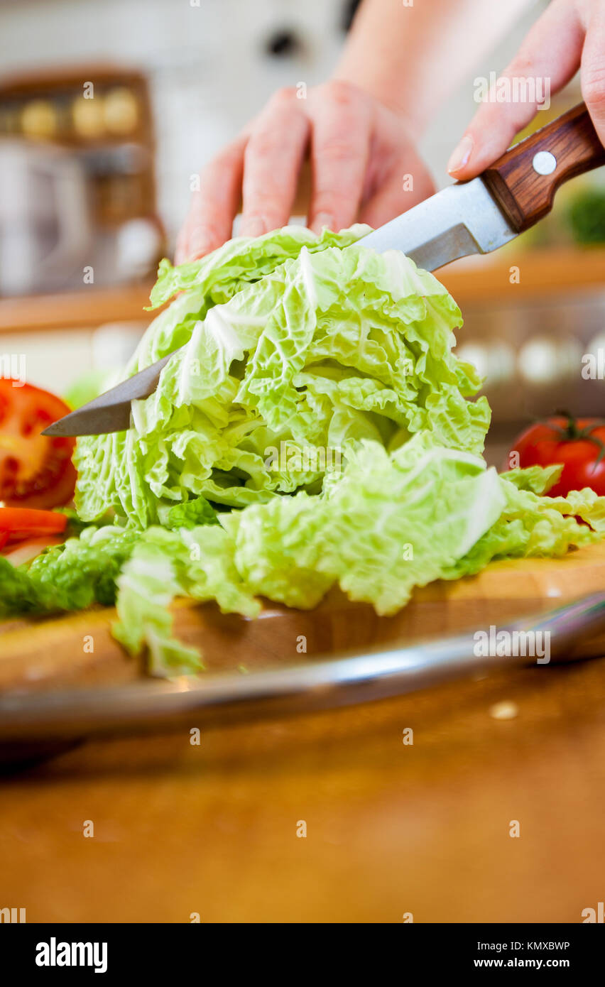 Woman's hands cutting lettuce, behind fresh vegetables Stock Photo - Alamy