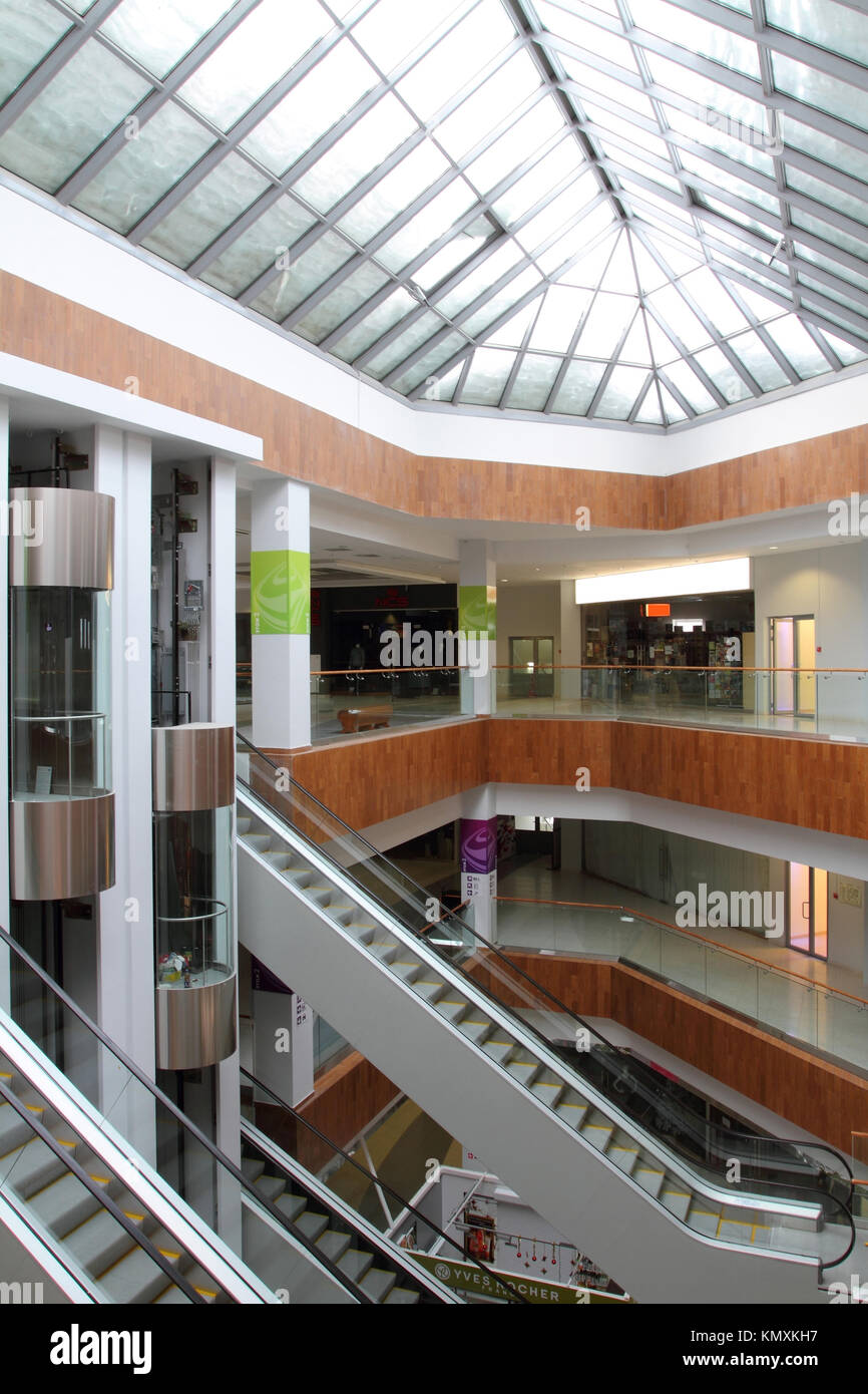 Hall with columns and escalators in huge shopping center. A view from ...