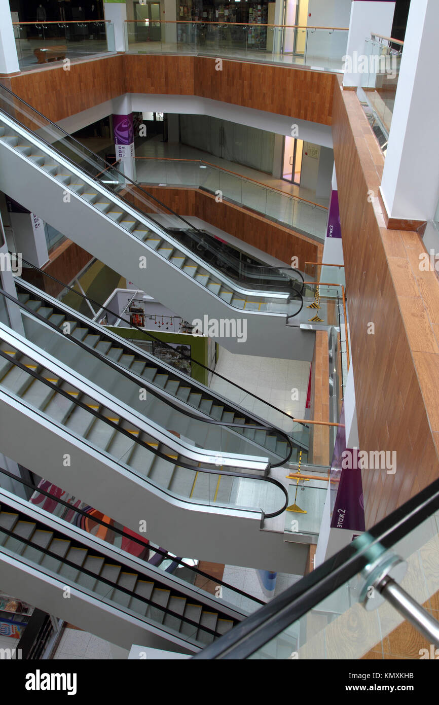Hall with columns and escalators in huge shopping center. A view from ...