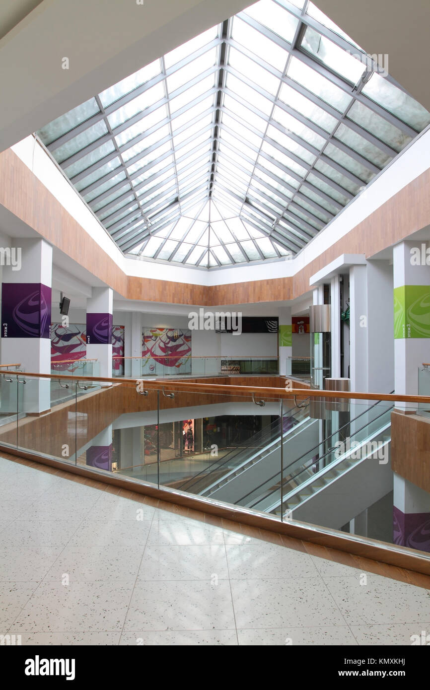 Hall with columns and escalators in huge shopping center. A view of the ...