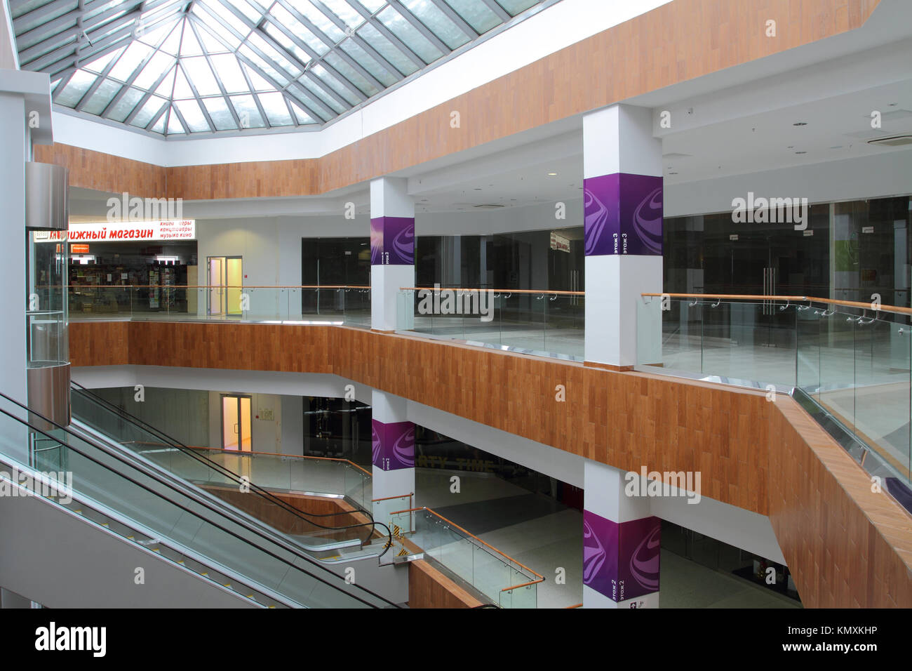 Hall with columns and escalators in huge shopping center. A view of the ...