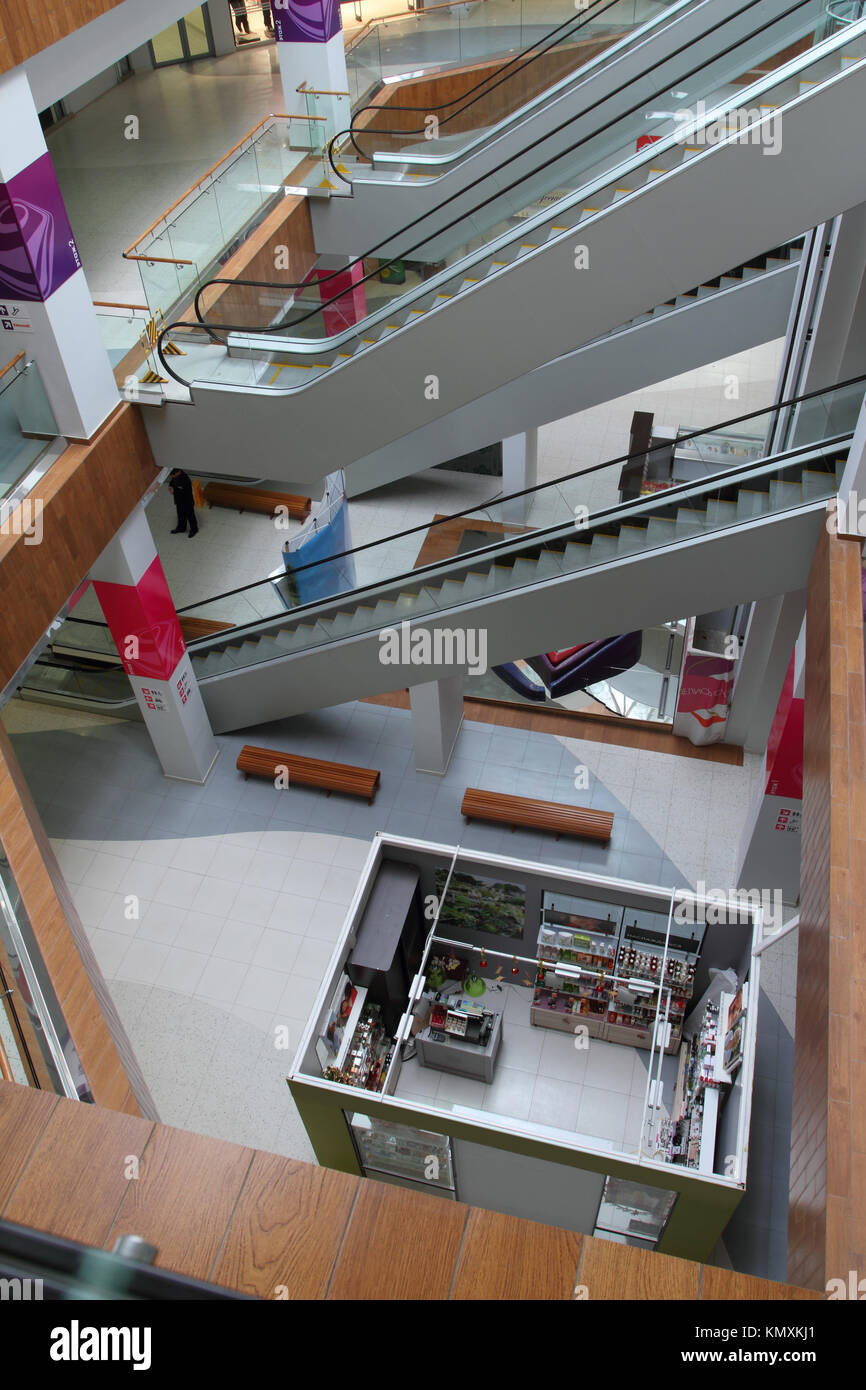 Hall with columns and escalators in huge shopping center. View of ...
