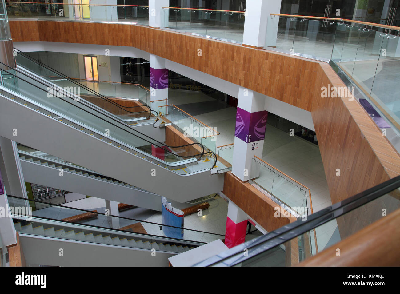 Hall with columns and escalators in huge shopping center. View of ...