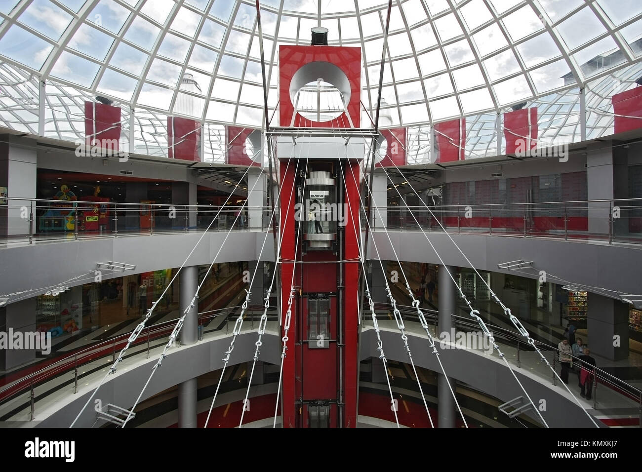 Huge hall of modern shopping centre with the glass lift and a ...